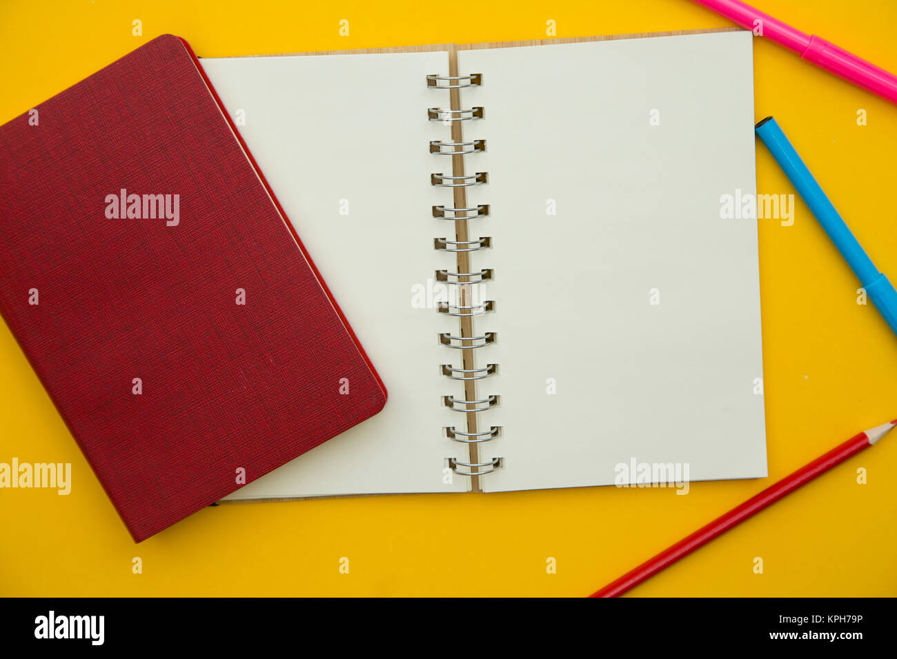 Write down creative ideas. An opened blank notebook, a closed notebook ...