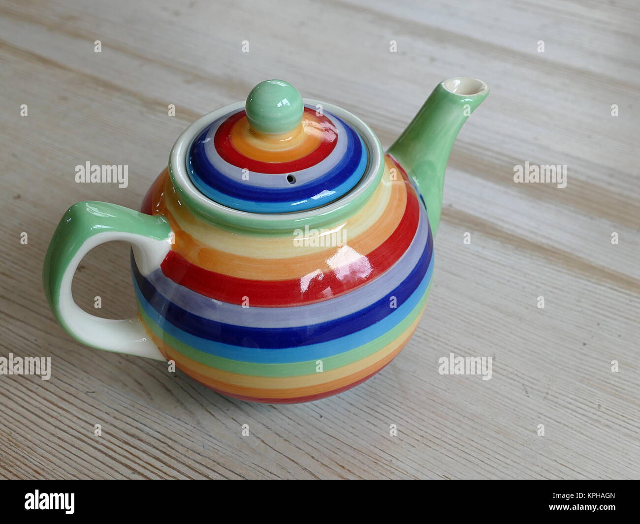 Colourful teapot on a wooden table Stock Photo - Alamy