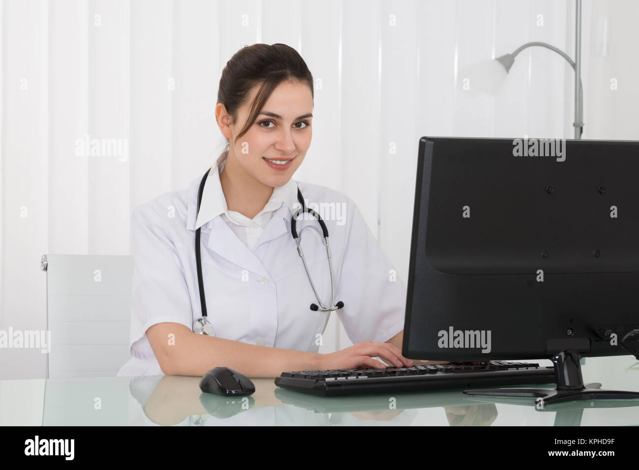 Female Doctor Working On Computer In Clinic Stock Photo - Alamy