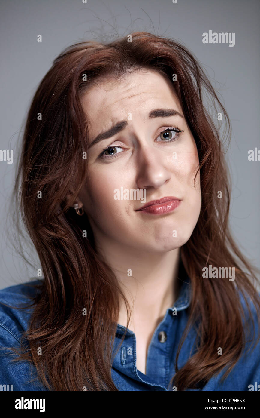 Woman is looking imploring over gray background Stock Photo - Alamy