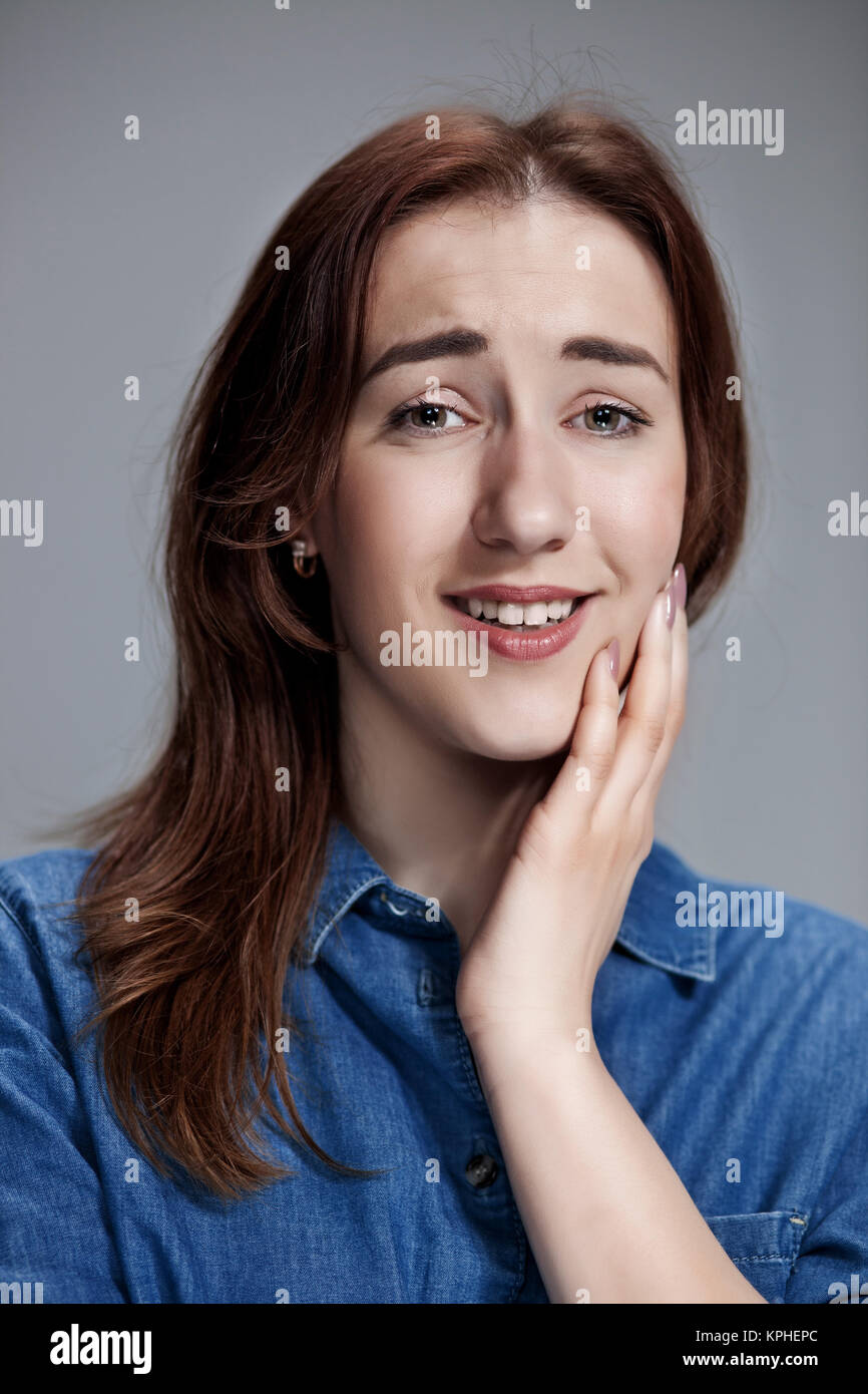 Woman is looking imploring over gray background Stock Photo - Alamy