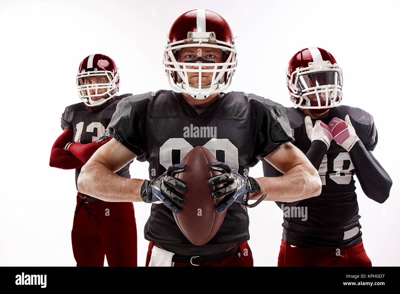 The three american football players posing with ball on white ...