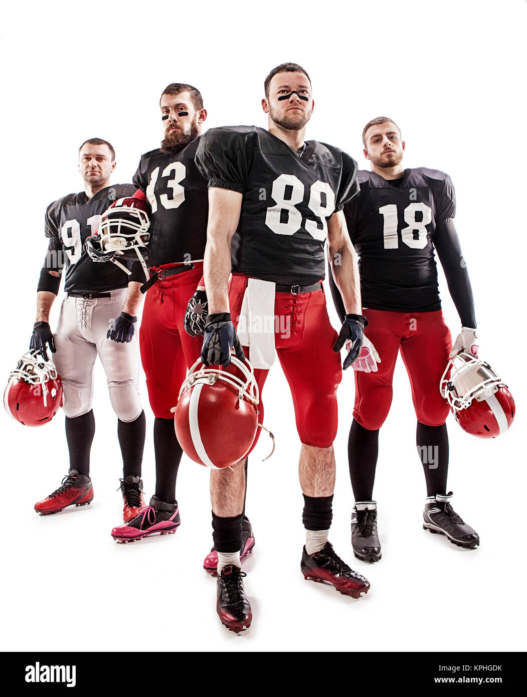 The four american football players posing with ball on white background ...