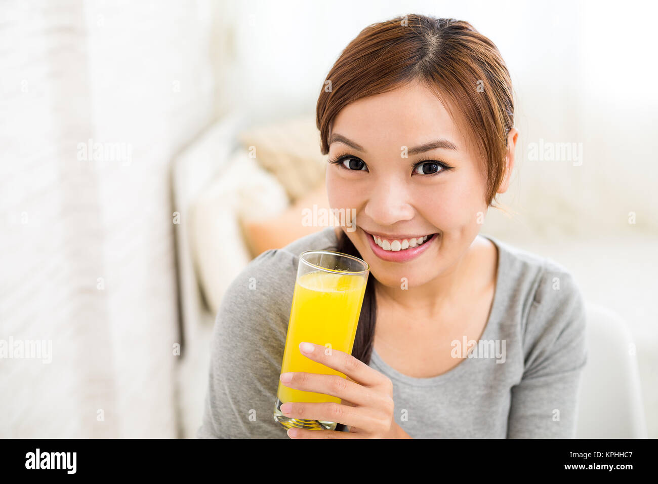 Woman enjoy her orange juice Stock Photo - Alamy