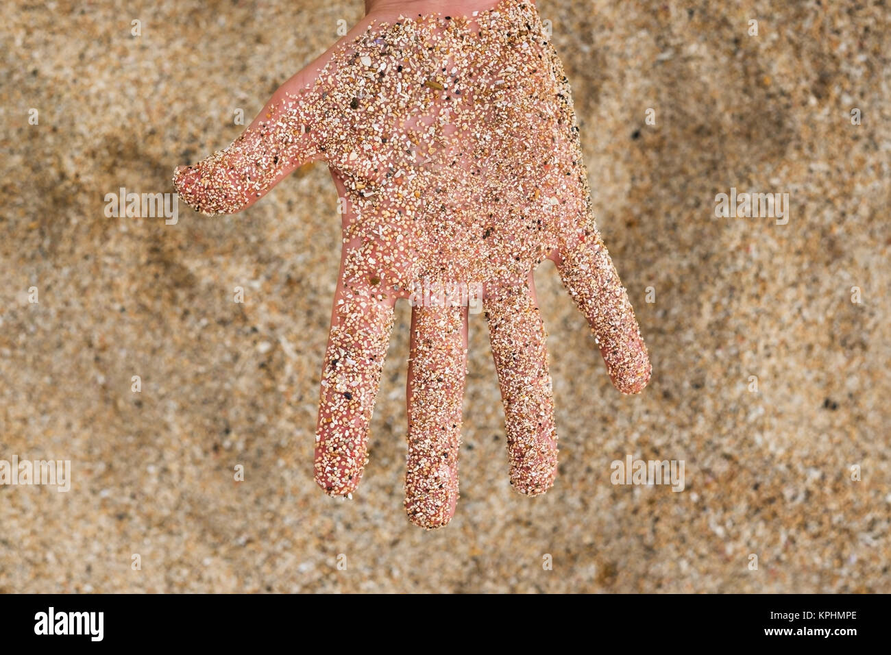 A caucasian hand in the sand on the beach while resting on vacation ...