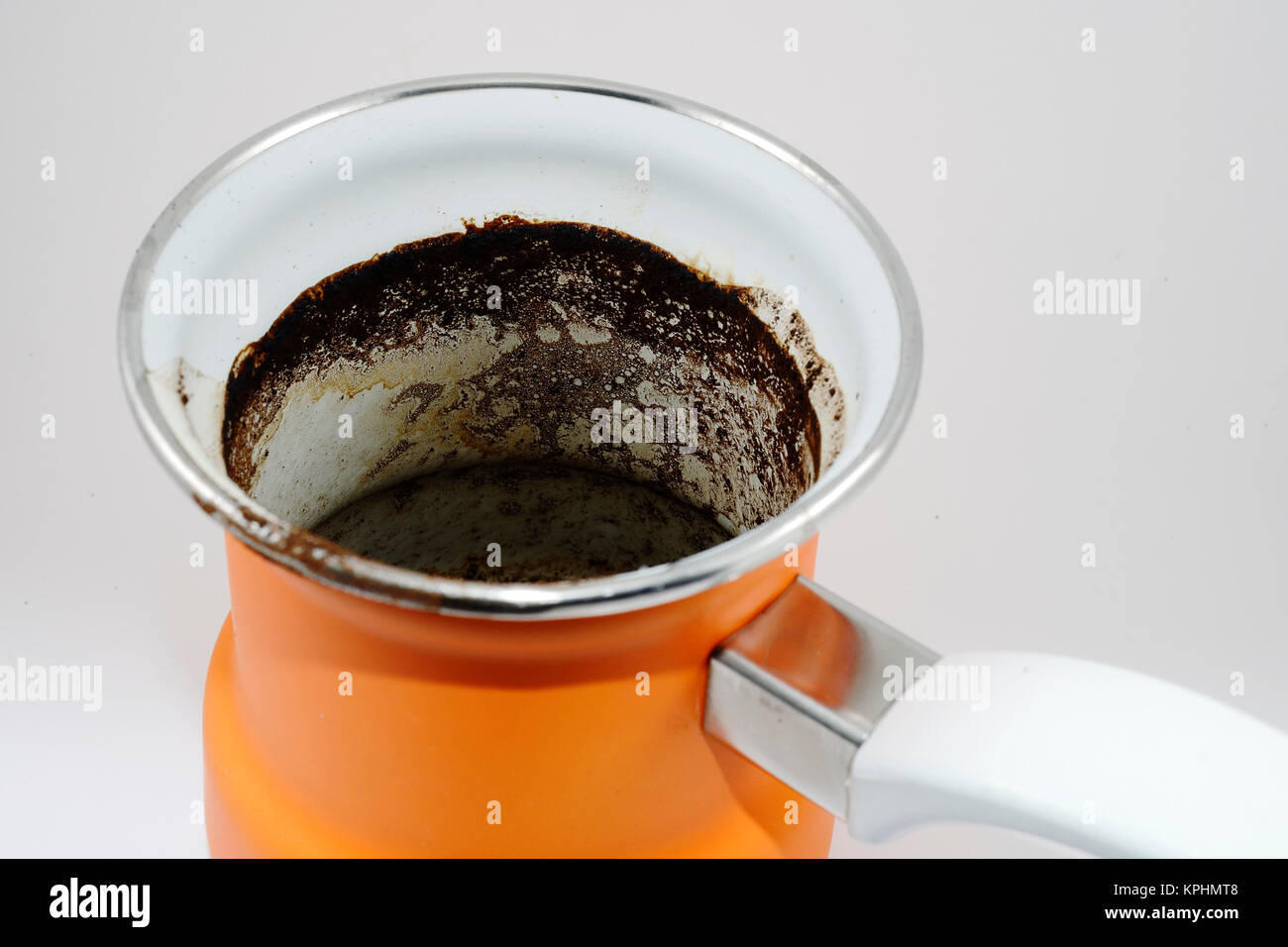 orange enamel coffee pot with coffee grounds Stock Photo - Alamy