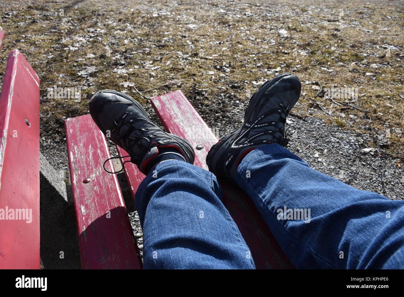Feet on park bench Stock Photo - Alamy