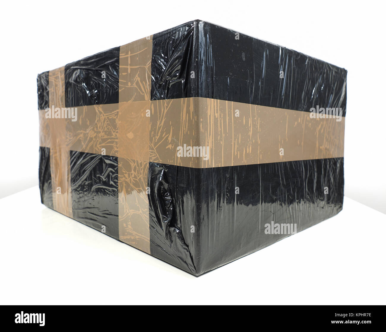 Small black packet or parcel for mail shipping on a white table with ...