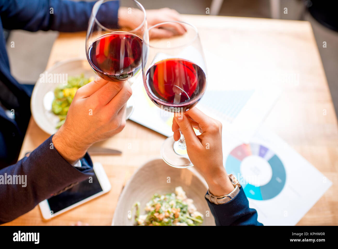 Clinking glasses with wine during the business lunch at the restaurant ...