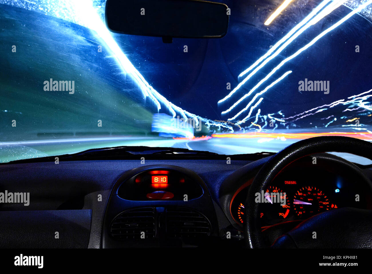 Inside a car traveling on the motorway with blurred streetlight trails ...