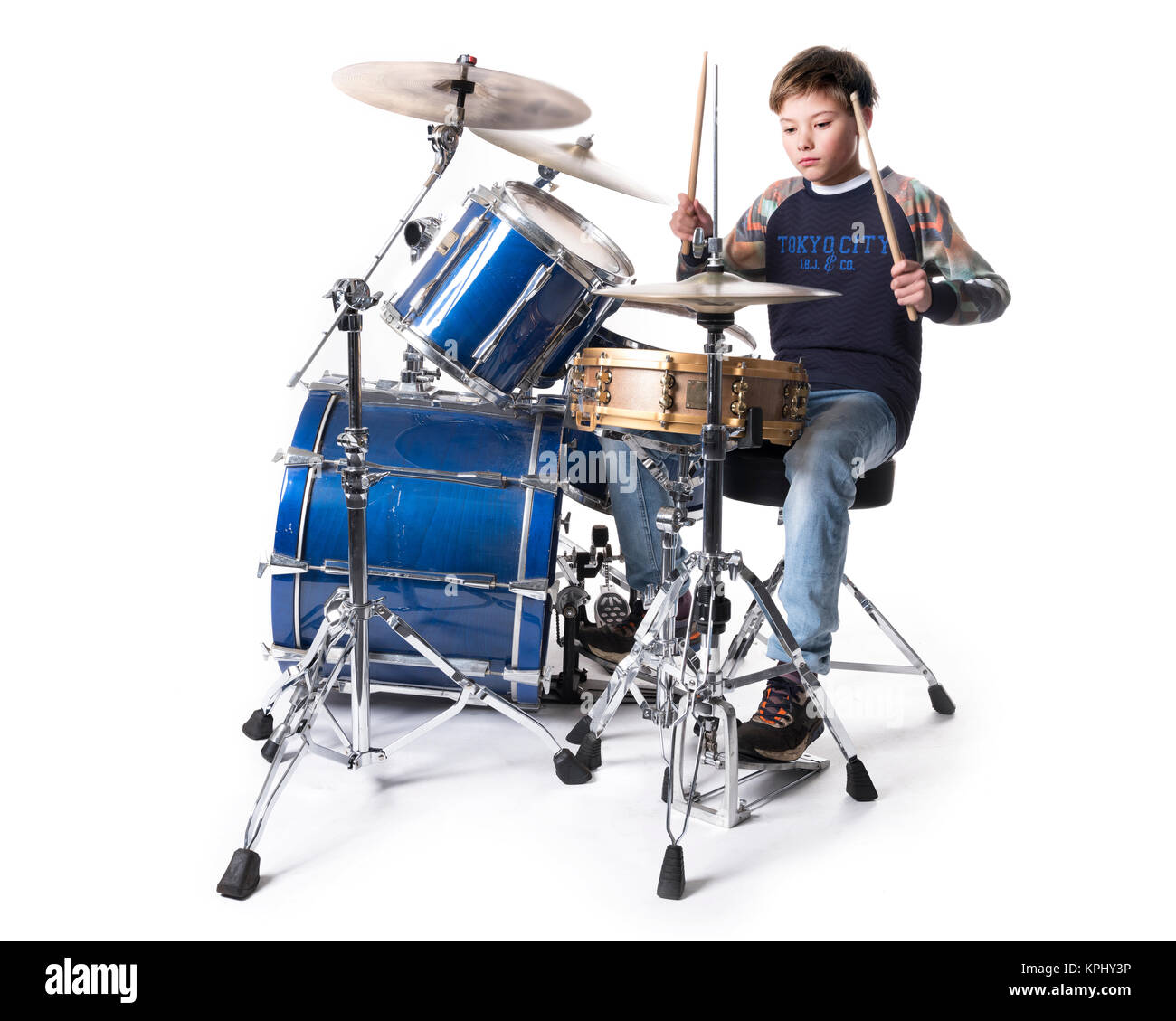 young blond boy at drum kit in studio against white background Stock ...