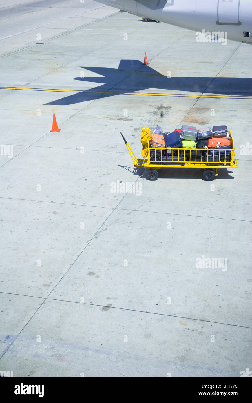 photo taken from inside plane on runway of baggage loaders trolley ...