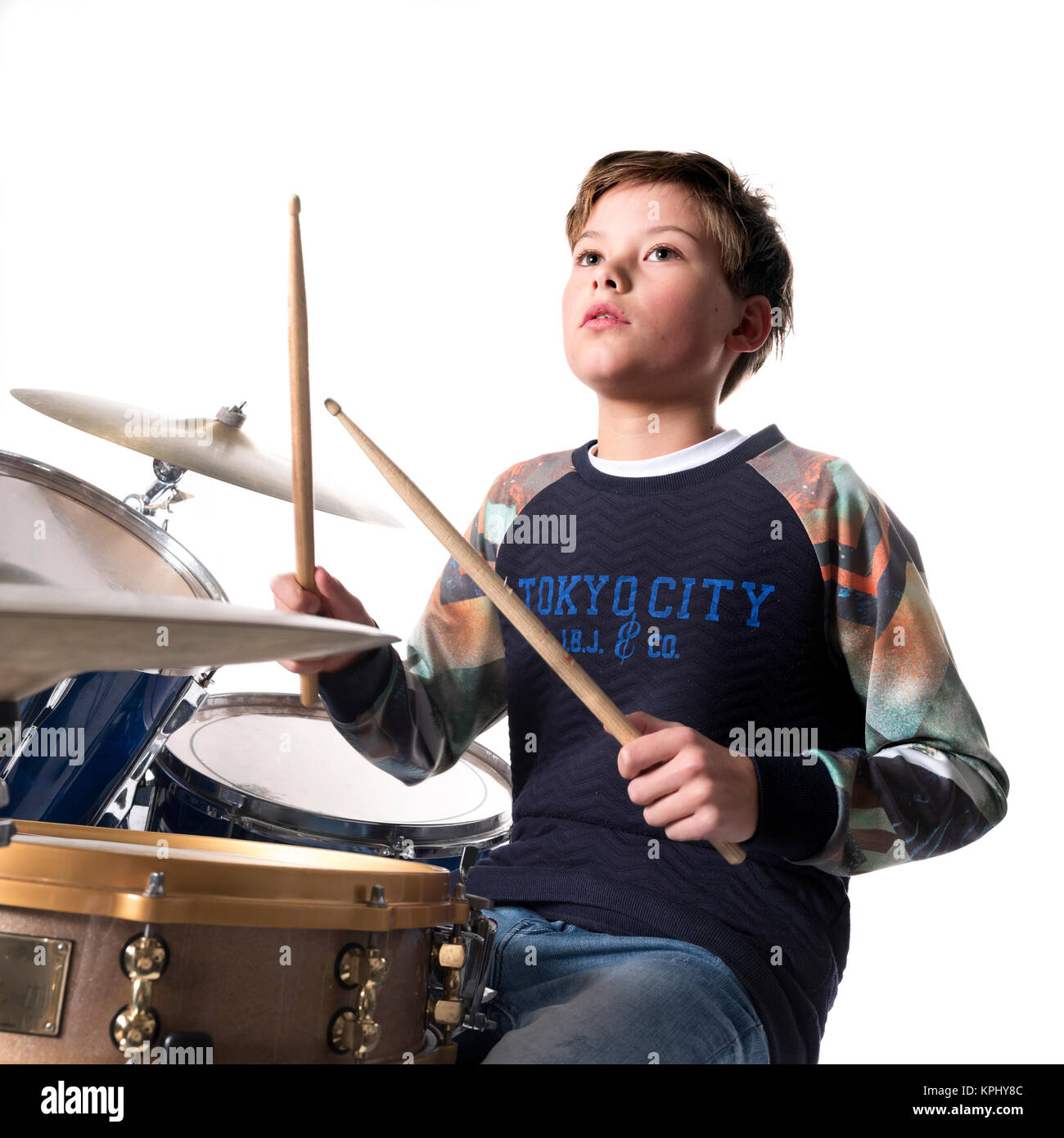 young blond boy at drum kit in studio against white background Stock ...