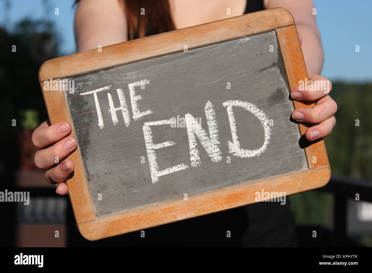 THE END written with chalk on slate shown by young female Stock Photo ...