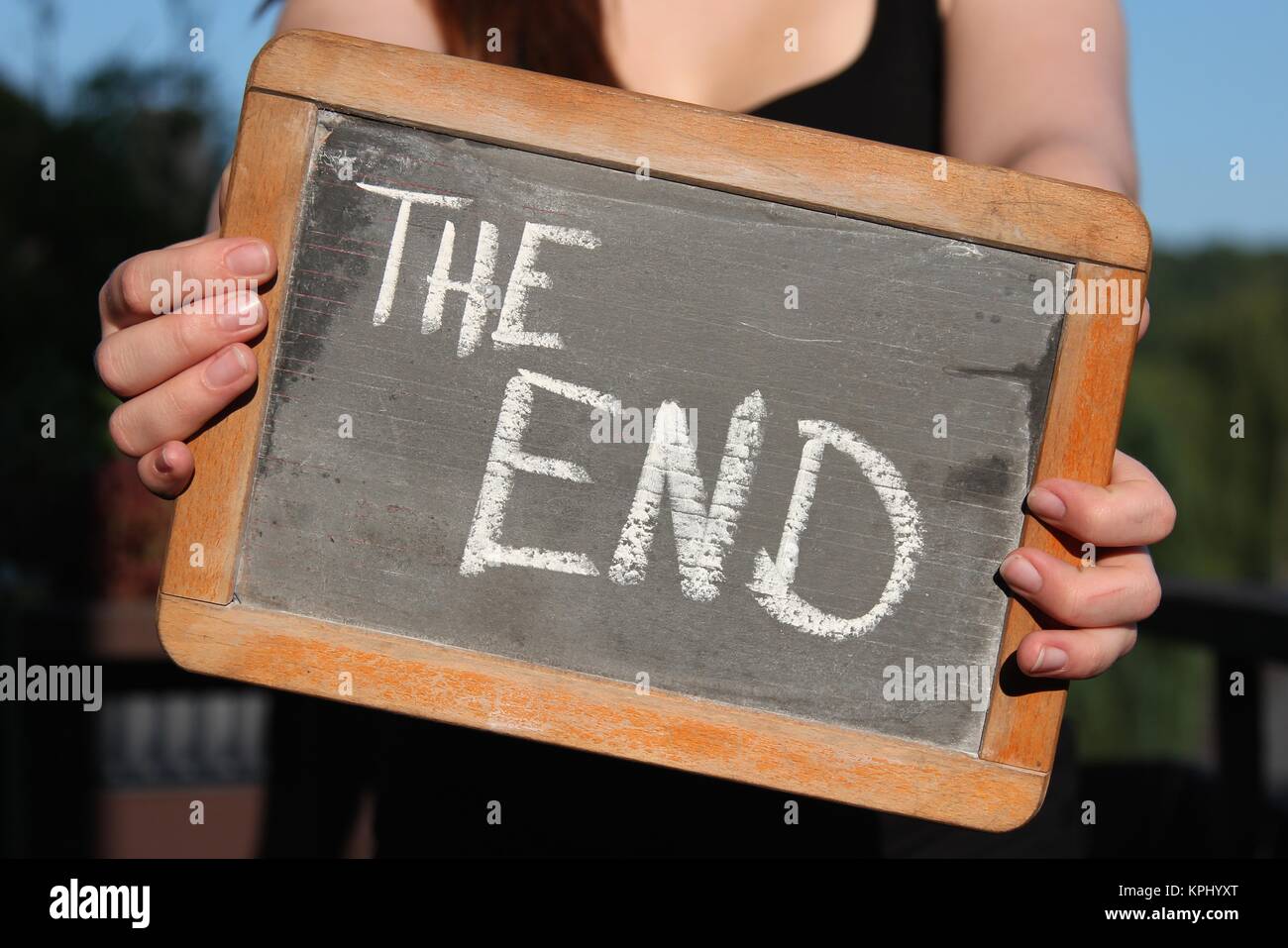 THE END written with chalk on slate shown by young female Stock Photo ...