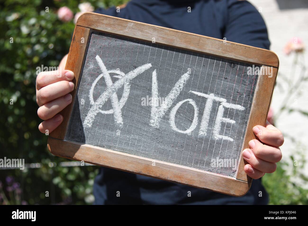 VOTE written with chalk on slate shown by young female Stock Photo - Alamy