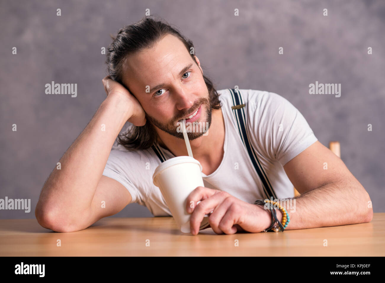 young man drinking soft drink in front of gray background Stock Photo ...