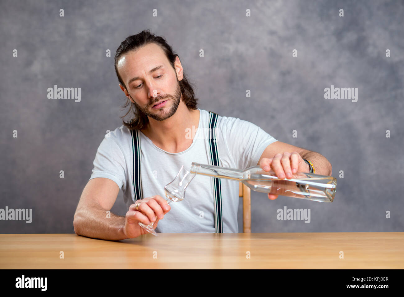 young man in front of gray background drinking clear spirit Stock Photo ...