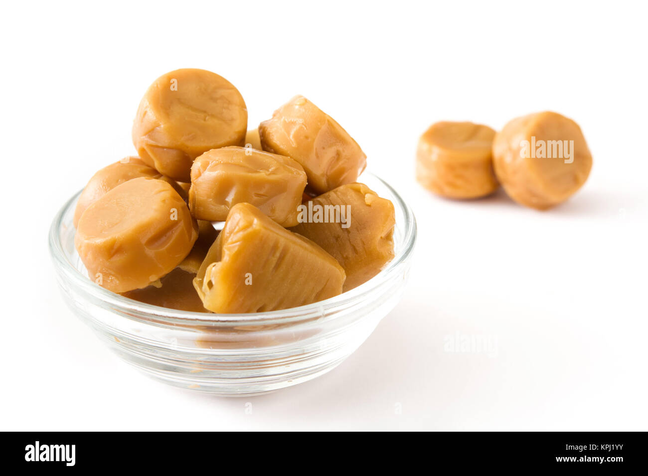 Toffee caramel candies in a crystal bowl isolated on white background ...