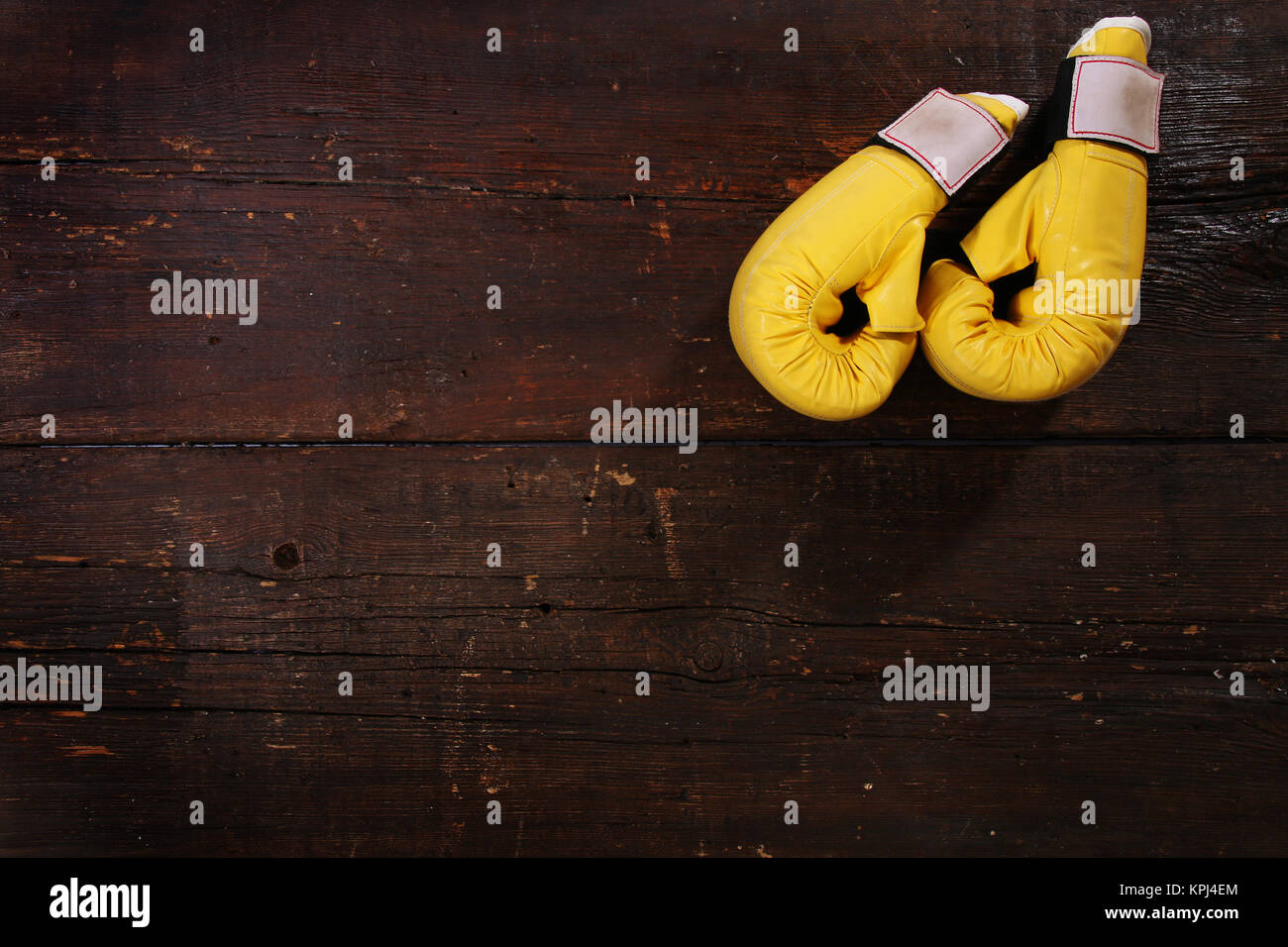 Yellow boxing gloves on a wooden floor Stock Photo - Alamy