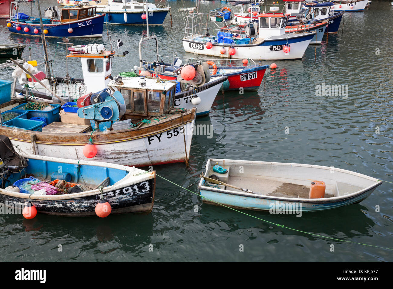 Small fishing boats float at their moorings in Mevagissey harbour ...