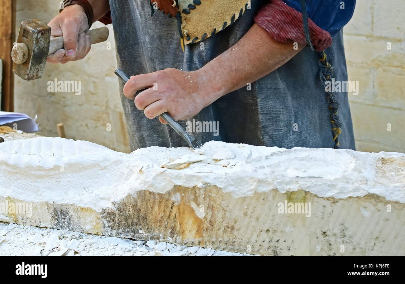 stonemason working on a cube of sandstone with hammer and chisel Stock ...