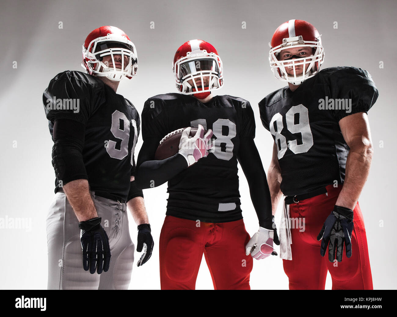 The three american football players posing with ball on white ...