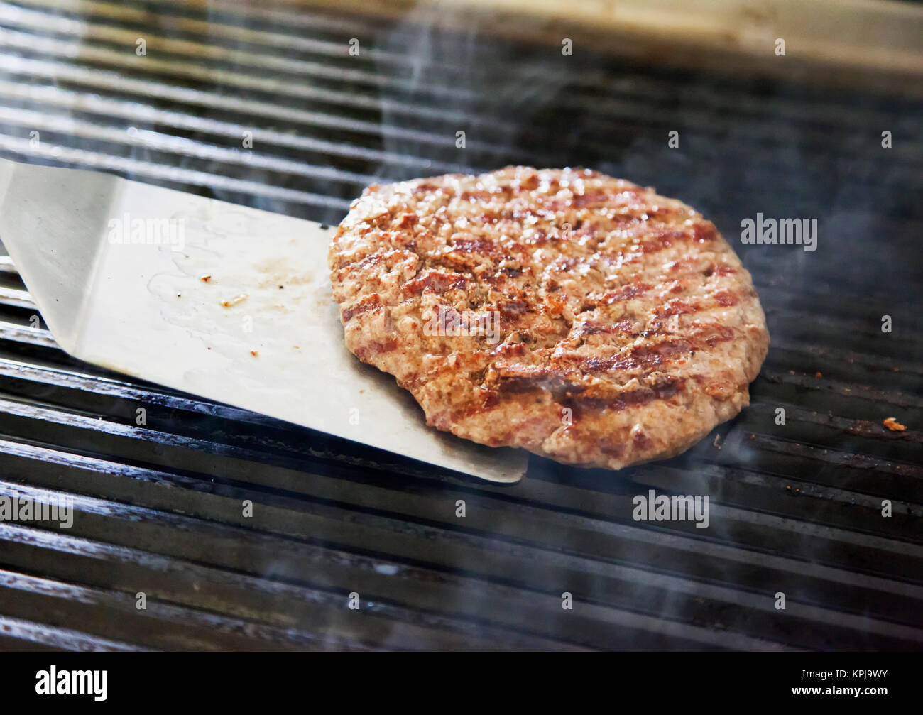 Hamburger over grill Stock Photo - Alamy