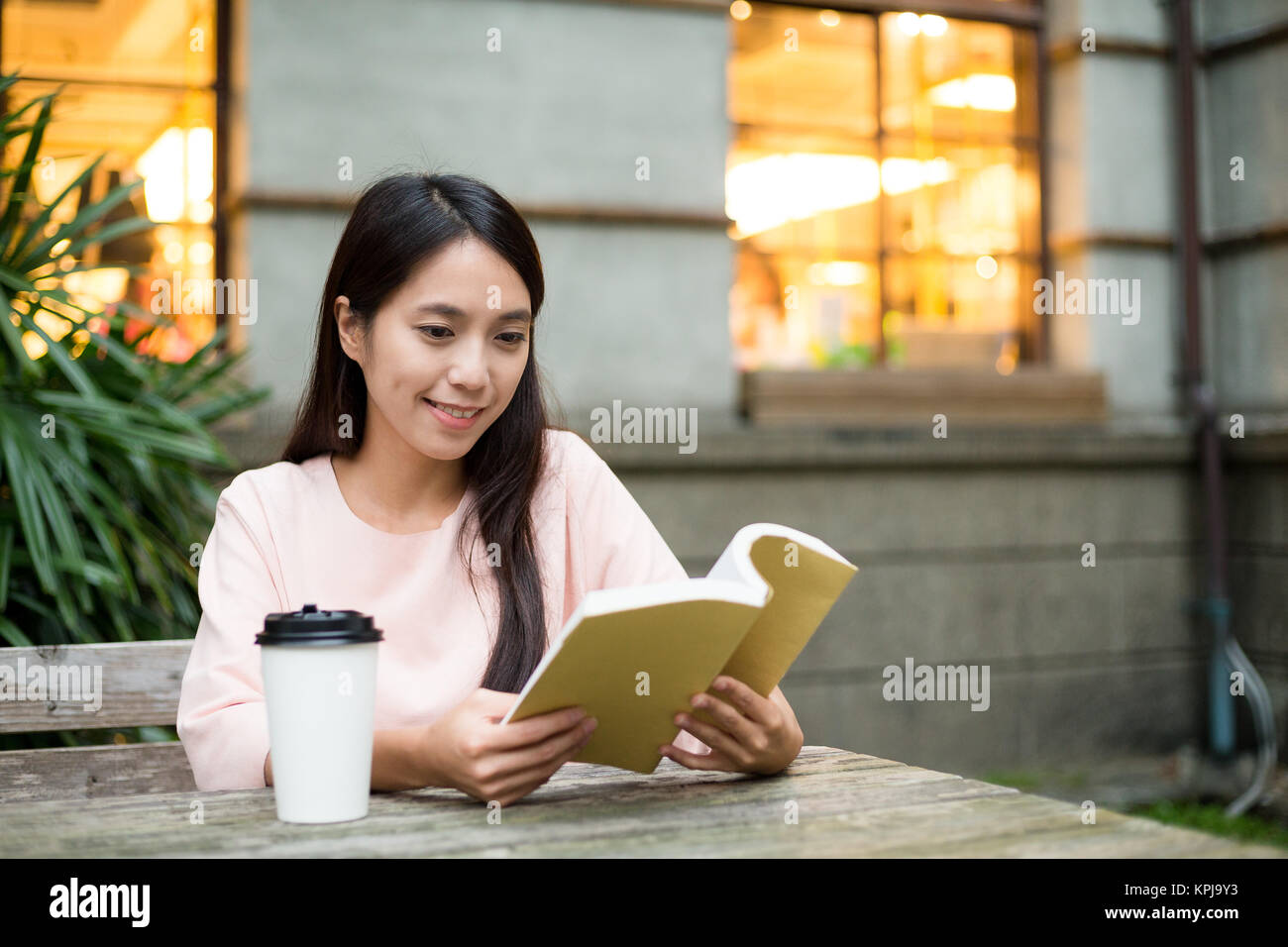 Woman reading boo at outdoor cafe Stock Photo - Alamy