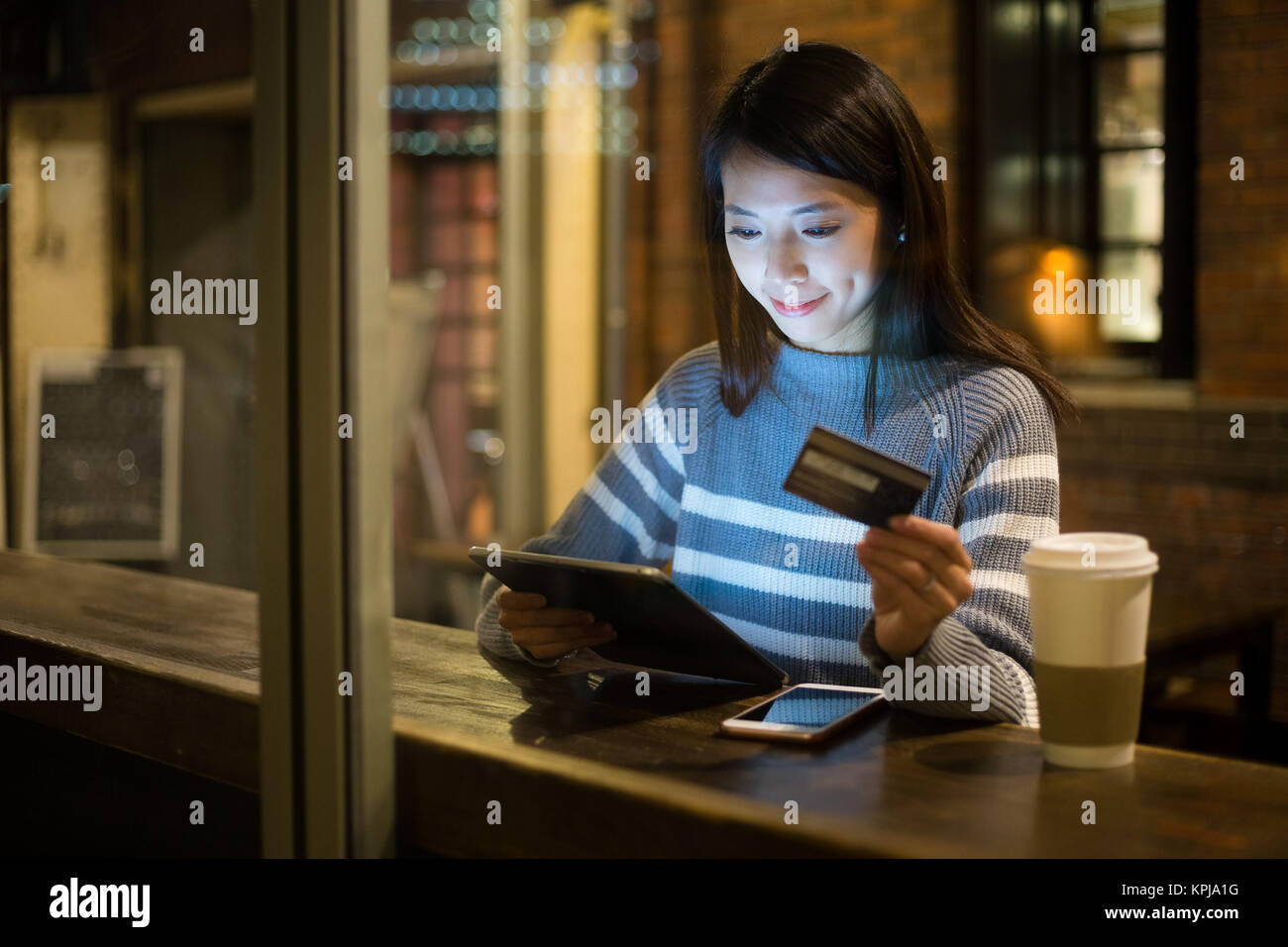Young woman using credit card for paying on tablet Stock Photo - Alamy