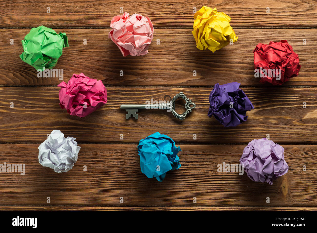 Set of multiple colorful crampled paper ball and key among them, placed ...