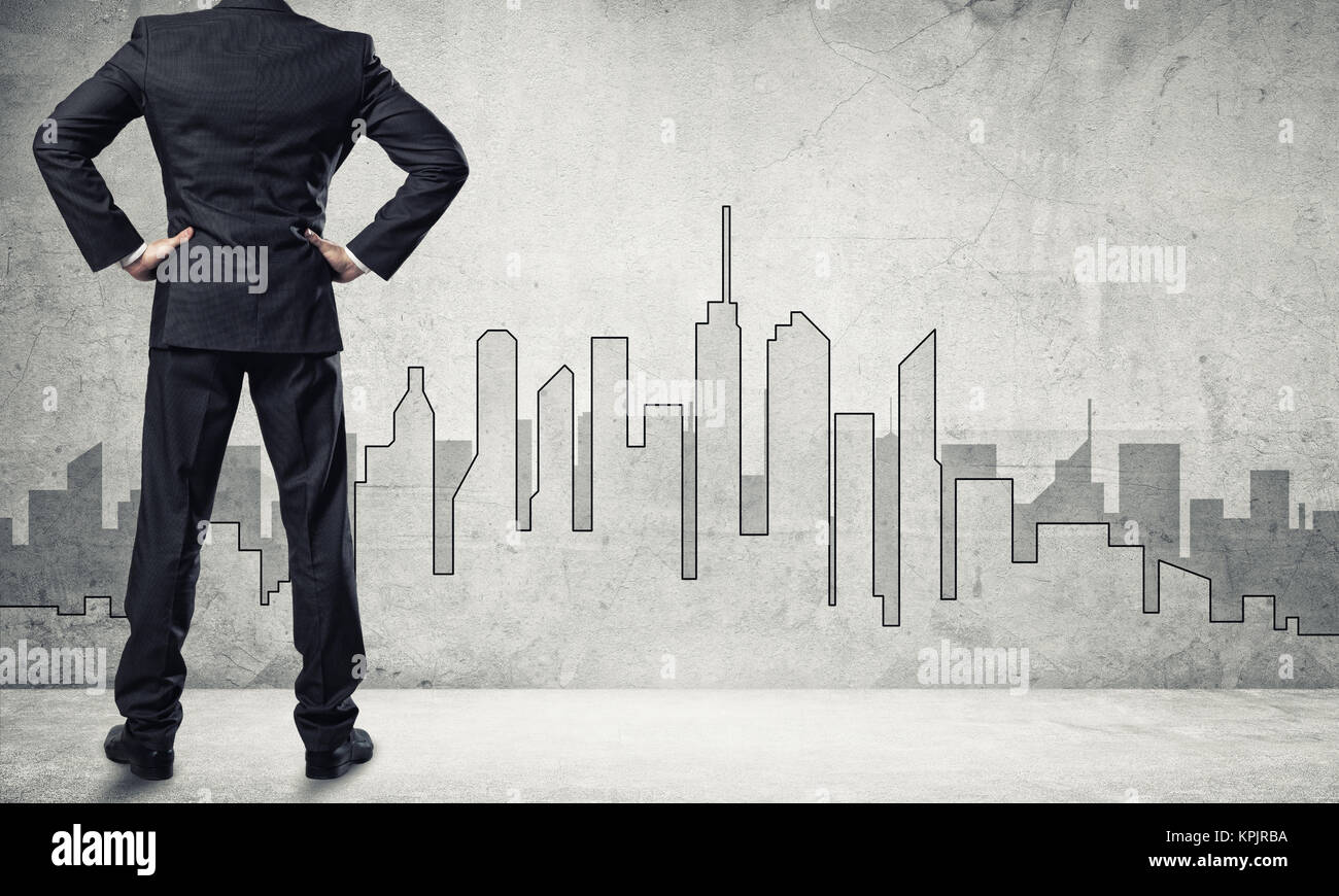 Back view of businessman and sketches of construction project on wall ...