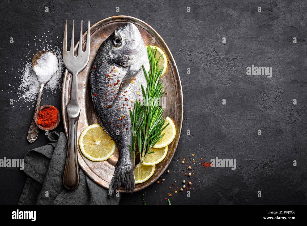 Fresh raw dorado fish on black background, top view Stock Photo - Alamy