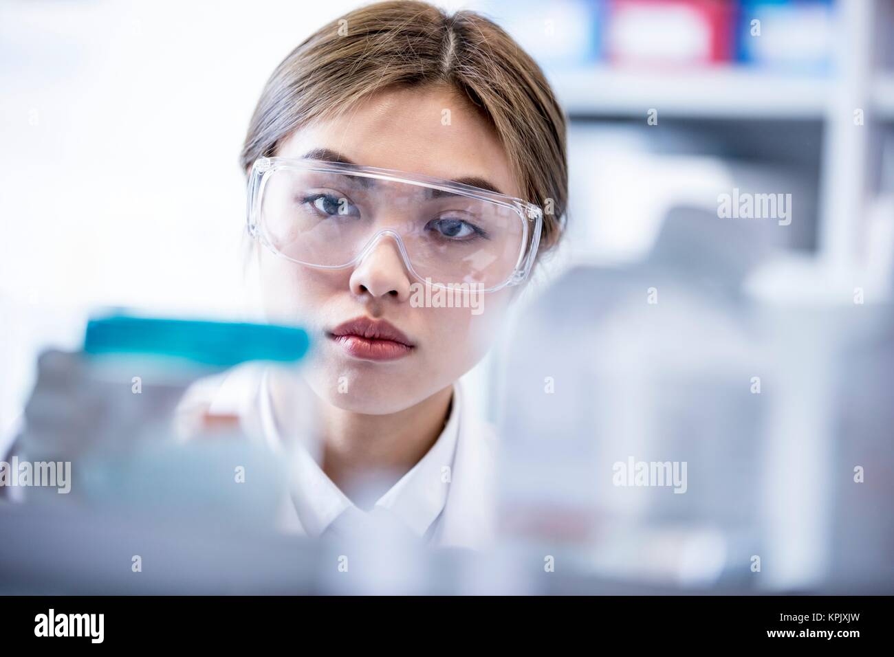 Female laboratory assistant wearing safety goggles Stock Photo - Alamy