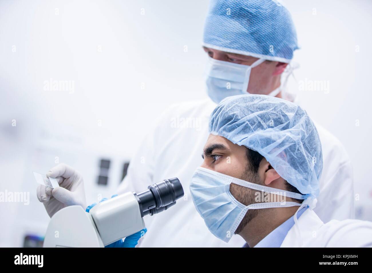 Male scientist wearing surgical cap using microscope Stock Photo - Alamy