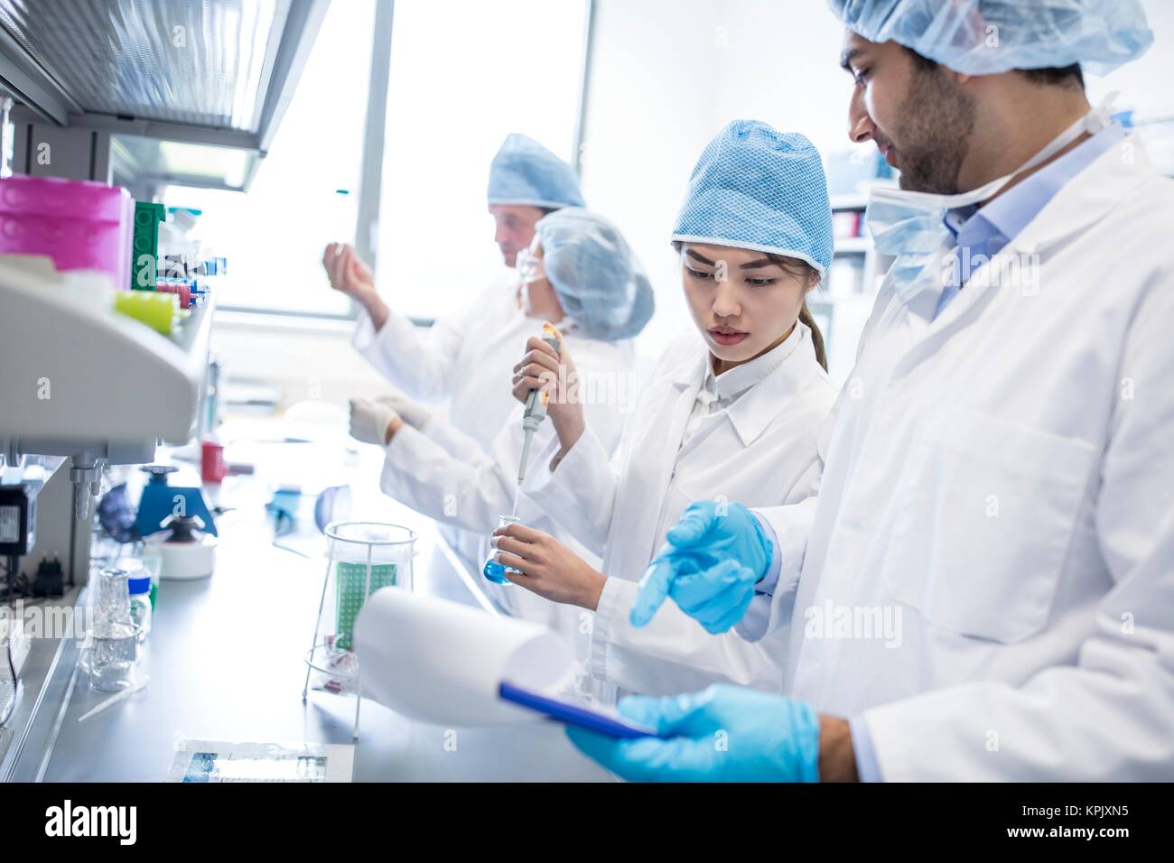 Scientists wearing protective clothing working in laboratory Stock ...