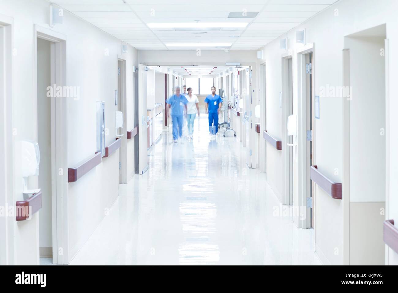 Doctors walking down hospital corridor Stock Photo - Alamy