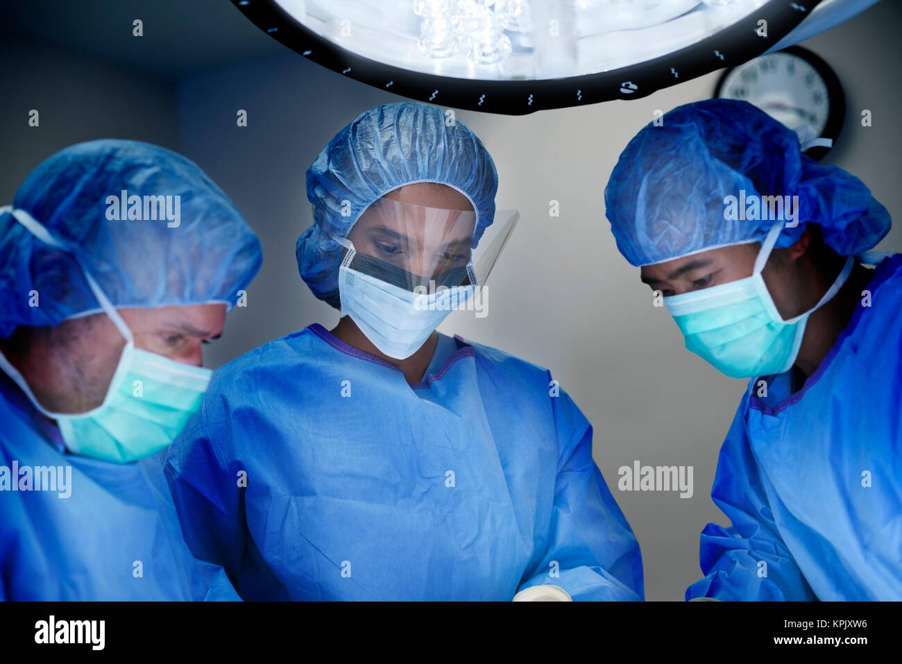 Doctors performing operation in hospital theatre Stock Photo - Alamy