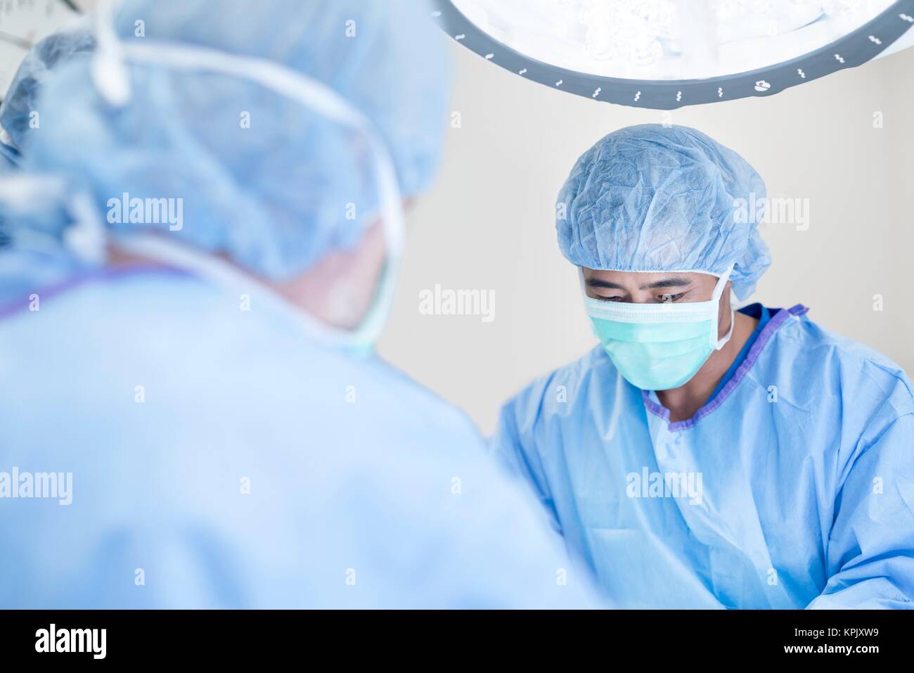 Doctor performing operation in hospital theatre Stock Photo - Alamy