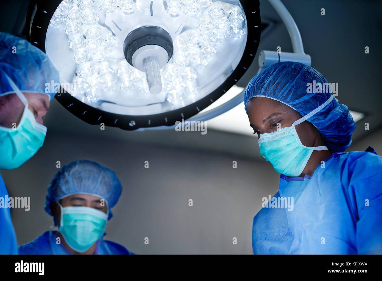 Doctors performing operation in hospital theatre Stock Photo - Alamy
