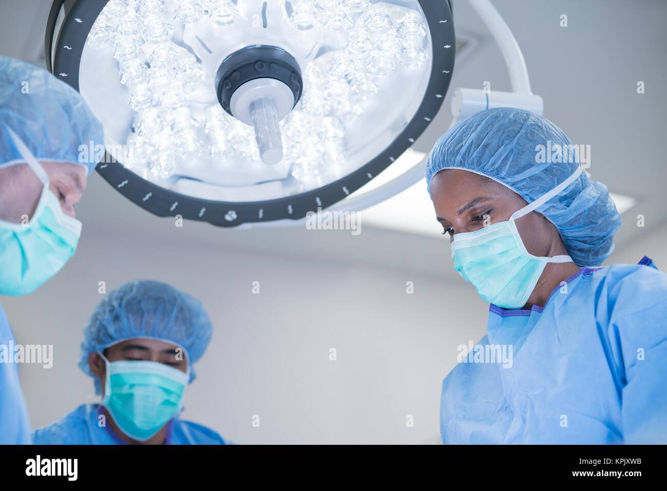 Doctors performing operation in hospital theatre Stock Photo - Alamy