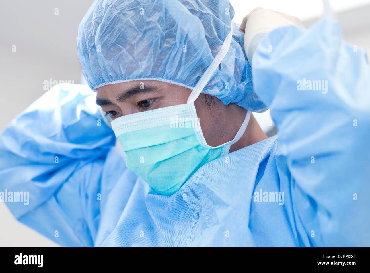 Male surgeon putting on surgical mask, portrait Stock Photo - Alamy