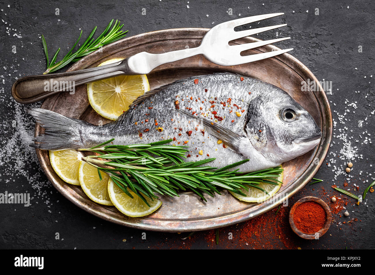 Fresh raw dorado fish on black background, top view Stock Photo - Alamy