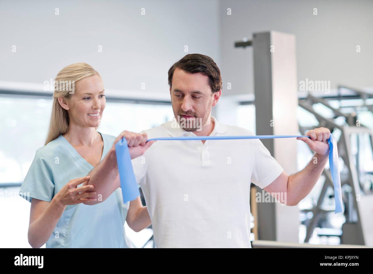 Female nurse showing man how to use resistance band Stock Photo - Alamy