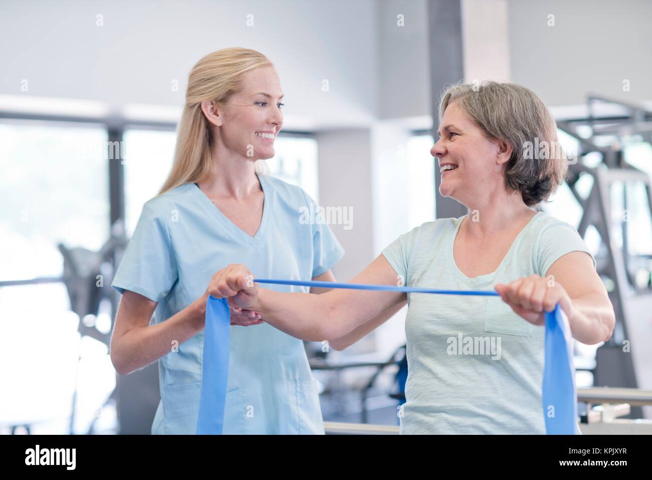 Female nurse showing woman how to use resistance band Stock Photo - Alamy