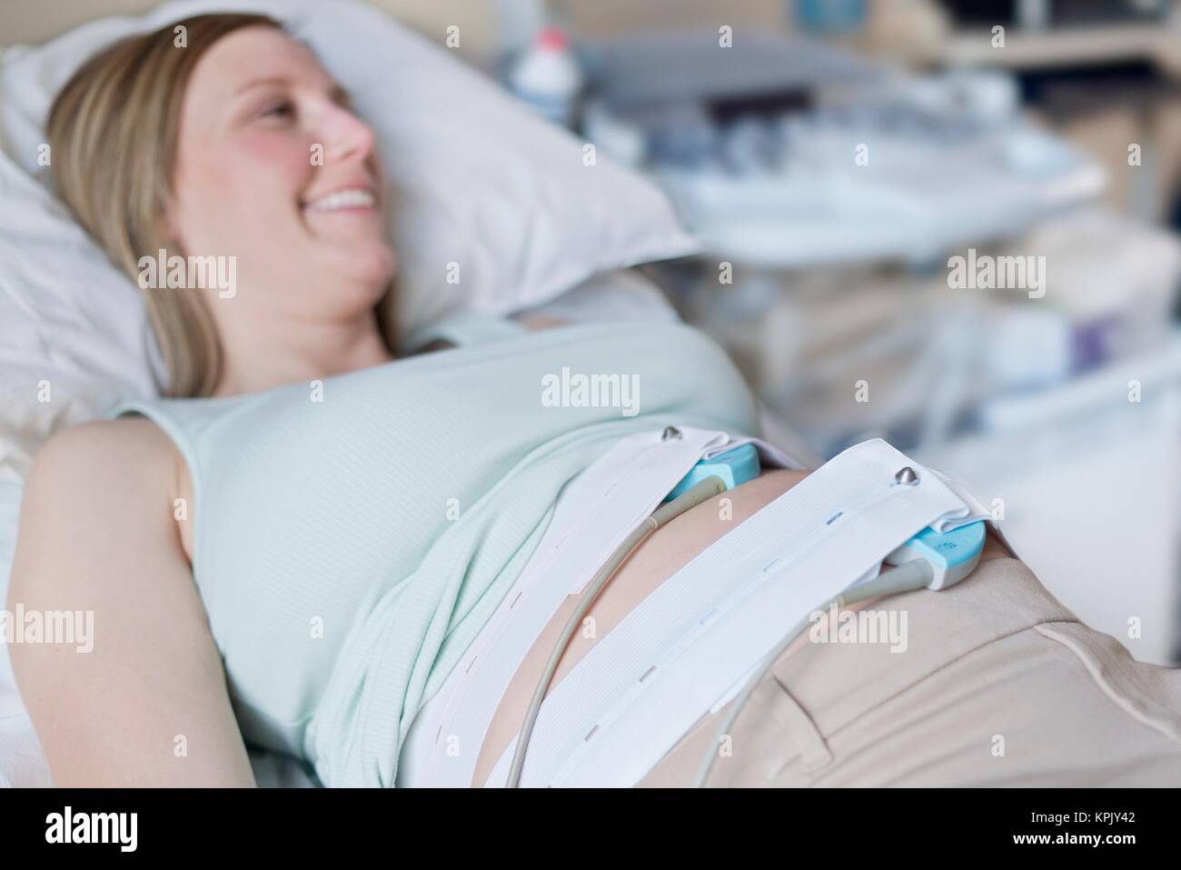 Pregnant woman with foetal heart rate monitor strapped to tummy Stock ...