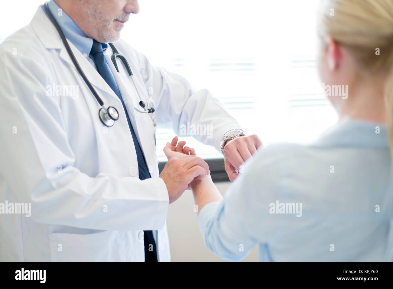 Male doctor taking patient's pulse Stock Photo - Alamy