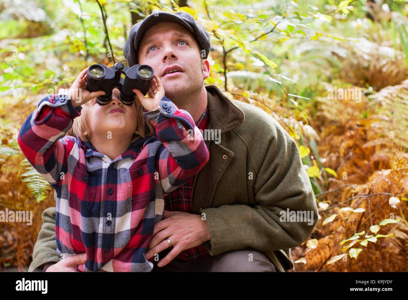 Father with son looking through binoculars Stock Photo - Alamy