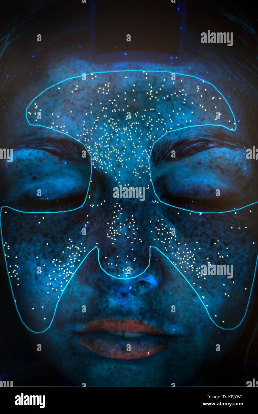 Image of young woman's face undergoing examination in skin clinic. This ...