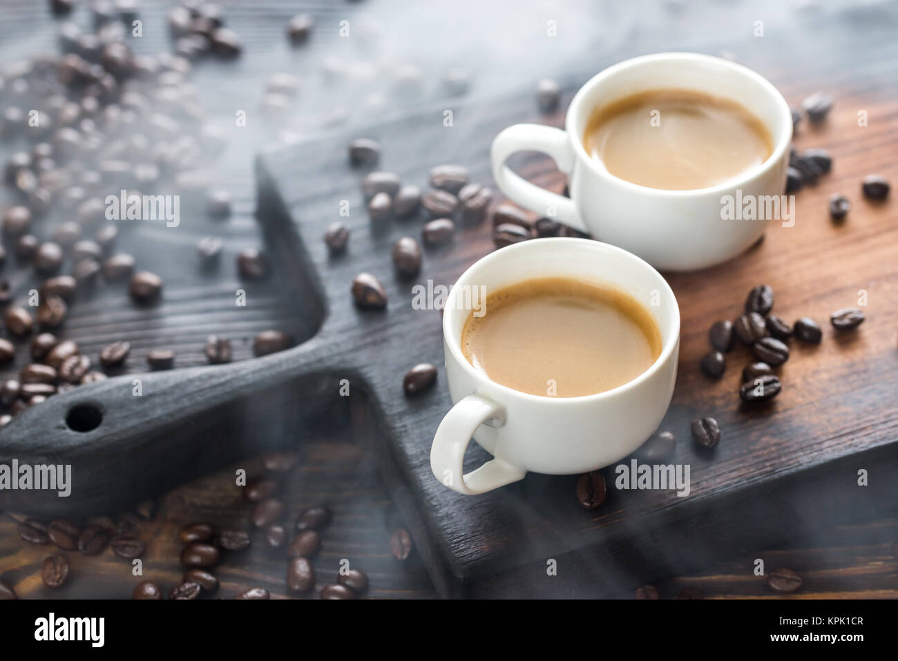 Two cups of coffee with coffee beans Stock Photo - Alamy